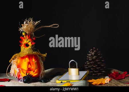 An illuminated Halloween pumpkin adorned with a hat and flowers ...