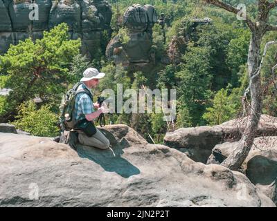 Schmilka - Germany, July 06, 2022: Tourist with camera is taking photos ...