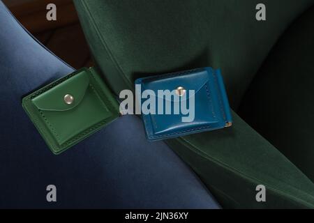 Two colored genuine leather wallets lying on a purple sofa indoors ...