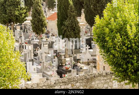 Public cemetery with top view of graves and tombstones and cypress ...