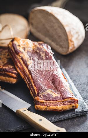 Whole smoked bacon on cutting board Stock Photo - Alamy