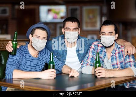 male friends in masks drinking beer at bar or pub Stock Photo - Alamy