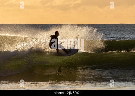 The surfer riding a wave in the early morning. Maroochydore, Australia ...