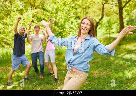 Cheering team and young woman with winner medal after a success at team ...