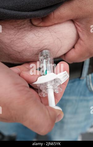 Patient with skin diseases and obesity injects himself with an ...