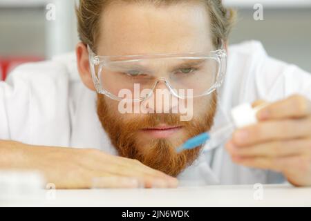 Laboratory worker using pipette, dripping liquid into petri dish Stock ...
