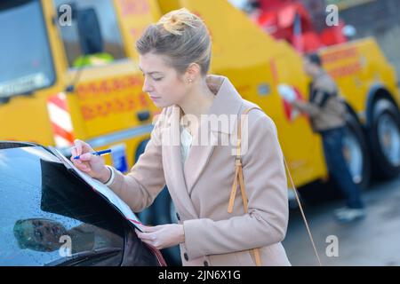 Woman filling in car insurance form at table Stock Photo - Alamy