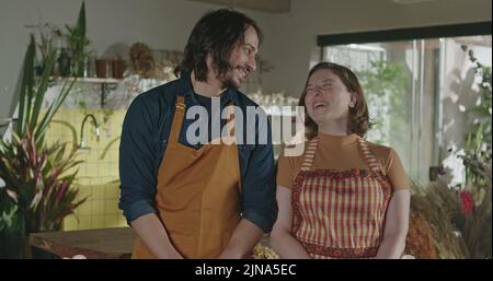 Portrait of two floriculture professionals inside flower shop. Male and ...
