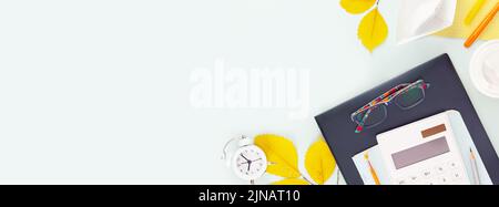 Set of blue stationery with notebooks and alarm clock on dark ...