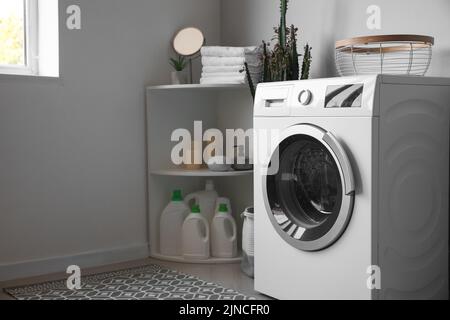 Shelving unit with bath supplies and laundry basket near blue wall ...