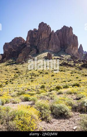 Steep rock formations and yellow Spring flowers below in Lost Dutchman ...