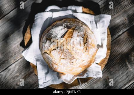 Traditional leavened sourdough bread with rought skin on a rustic ...