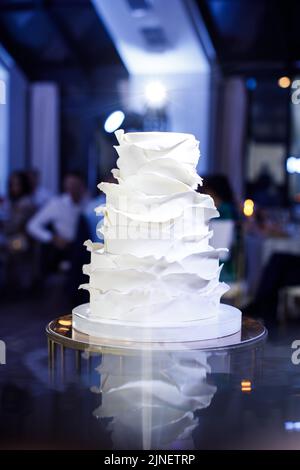 Multilevel wedding cake on the table decorated with flowers Stock Photo ...