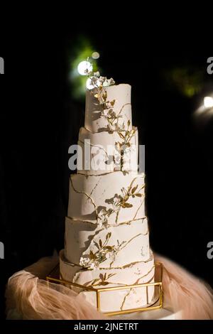 Multilevel wedding cake on the table decorated with flowers Stock Photo ...