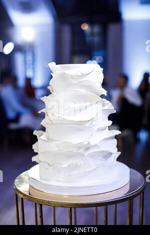 Multilevel wedding cake on the table decorated with flowers Stock Photo ...