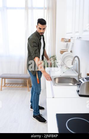 Arabian man with tape measure measuring kitchen cabinet, banner,stock ...