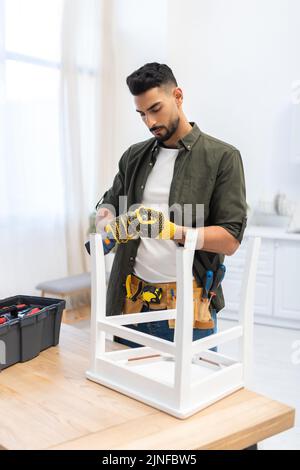 Young arab man holding electric toothbrush doing ok sign with fingers ...