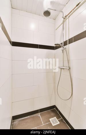 Bathroom with white tiled walls and open shower near sink base cabinet ...