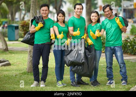 Happy young Asian woman showing heart gesture on blue background ...