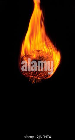 A vertical closeup of a dandelion on fire on a black background Stock ...