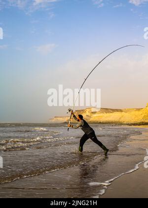 A Fisher man throwing his hook with his fisher rod Stock Photo - Alamy