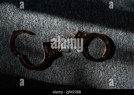 Classic chain handcuffs hanging on black background Stock Photo - Alamy