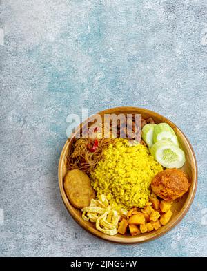 Indonesian yellow rice served with egg, vermicelli, potato fried chili ...