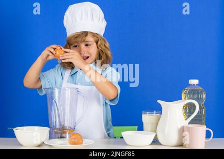 Child chef isolated on blue. Funny little kid chef cook wearing uniform ...