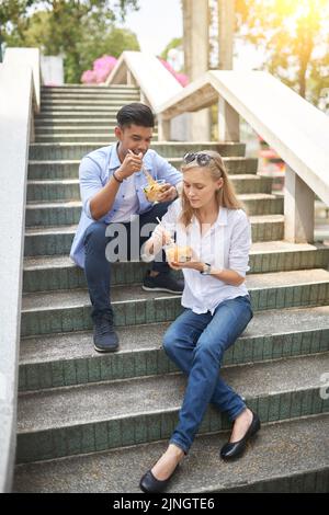 Chinese and Caucasian man sitting on grass with coats off Stock Photo ...