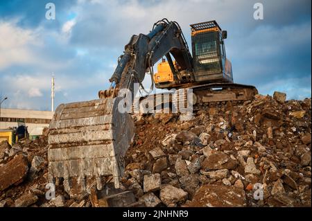 Bucket of excavator full of dismantled building leftovers Stock Photo - Alamy