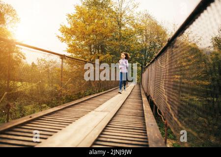slender young female runner middle-distance running at stadium in ...