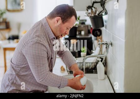 Man with Down Syndrome washing dishes in the kitchen Stock Photo - Alamy