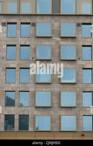 A vertical shot of a modern stone building with rows of windows Stock ...
