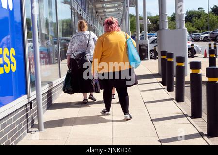 A rear view of an overweight large fat woman wearing red fleece sitting ...