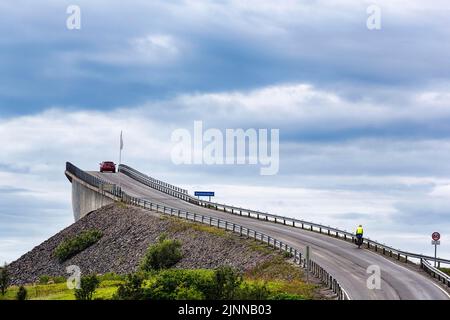 Cyclist and car on Atlantic Road, curvy bridge Storseisundbrua ...