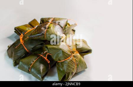View of homemade Nicaraguan nacatamales with banana leaf on white ...