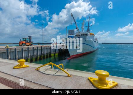 Excursion ship, containers being unloaded by crane, in the outer ...