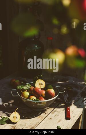 Many ripe pears in a colander on wooden garden table Stock Photo - Alamy