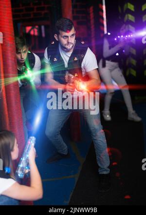 Guy in colored beams during laser tag game Stock Photo - Alamy