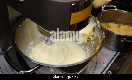 male hands add the ingredient cream for baking in the bowl of a food ...