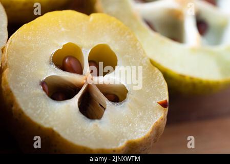 Close-up of Japanese quince. Cross-sectioned fruit with seeds in a seed ...