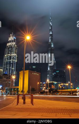 A vertical shot of the modern skyscrapers at Dubai Marina illuminated ...
