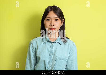 Brunette woman standing over yellow background shouting and screaming ...