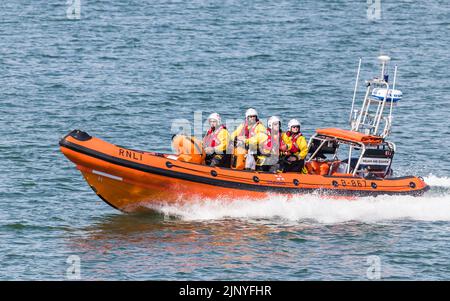 RNLI Life boat racing into the sea after launching from the shore at ...