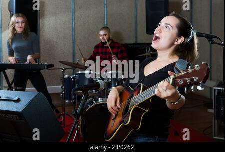 excited girl rock singer with guitar during rehearsal Stock Photo - Alamy