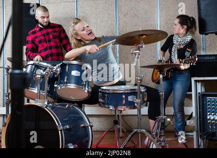 Rehearsal of music group with female drummer Stock Photo - Alamy