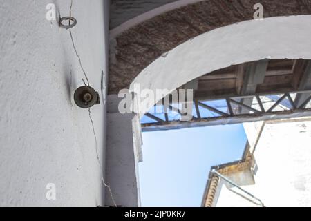 Mechanically operated doorbell on a torsion spring actuated by a wire ...