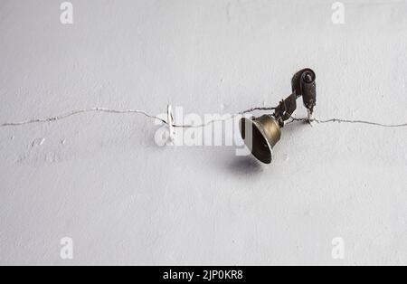 Mechanically operated doorbell on a torsion spring actuated by a wire ...