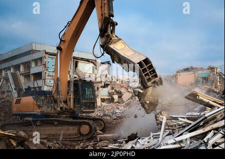 Excavator with hydraulic press breaks concrete leftovers Stock Photo - Alamy