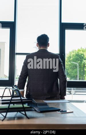 Back view image of handsome young guy sportsman make exercises outdoors ...